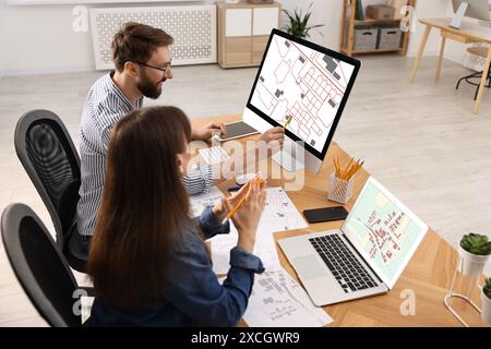 Cartographers working with cadastral maps at table in office Stock ...