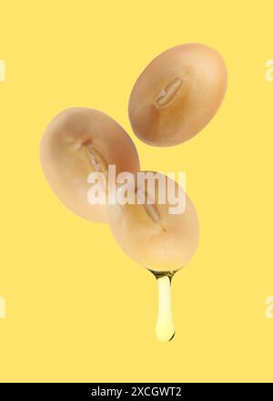 Cooking oil dripping from soybeans on yellow background Stock Photo - Alamy