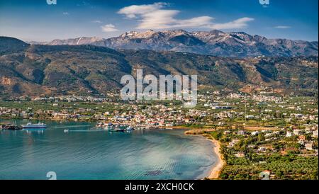 Scenic view of cityscape at seashore with snowcapped mountains in ...
