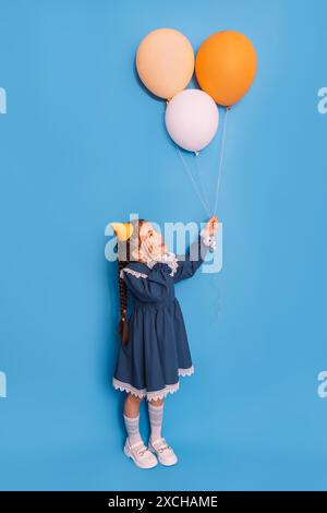 The girl is holding inflatable balloons in the form of New Year's ...