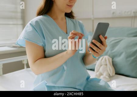 Pregnant woman checking belly on blue background Stock Photo - Alamy