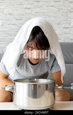 Teenage boy, child, doing steam inhalation at home to soothe and open ...