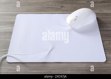 White wired mouse and mousepad on black textured table, top view Stock ...