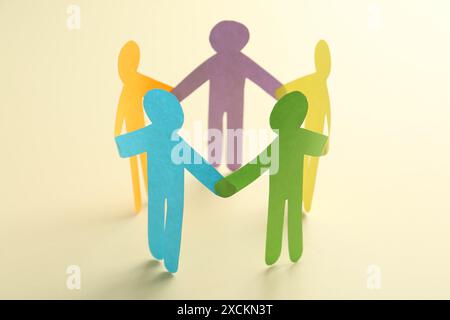 Paper human figures on beige background. Inclusion concept. Banner for ...