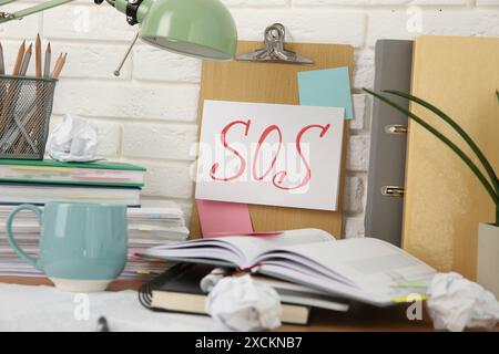 Note with word SOS and stationery on computer at workplace Stock Photo ...