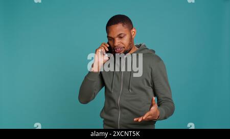 Irked african american man fighting with friends during telephone call ...