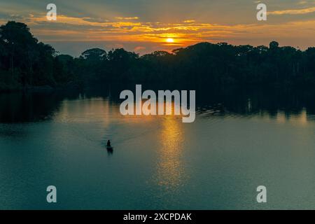 Man silhouette in canoe at sunrise, Amazon rainforest. Amazon river ...