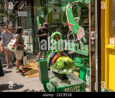 A child dressed as a pickle takes a ride on a pickle at the GrilloÕs ...