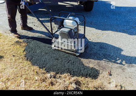 Manual tamping of asphalt using tamping compacting vibratory at parking ...