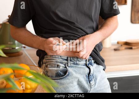 Diabetic young man giving himself insulin injection at home Stock Photo ...