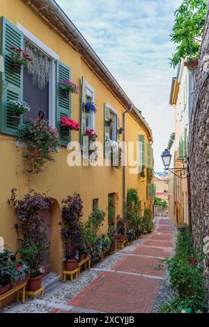 View down very pretty and colourful alley/street in Menton, France ...