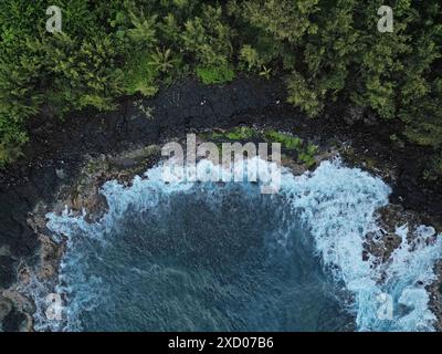 Aerial overhead view of beautiful breaking ocean waves against a rugged ...