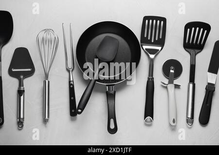 Different spatulas and other kitchen utensils on grey background, flat ...