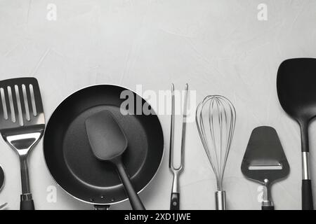 Different spatulas and other kitchen utensils on beige background, flat ...