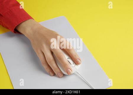 Woman using modern wired computer mouse on beige background, top view ...