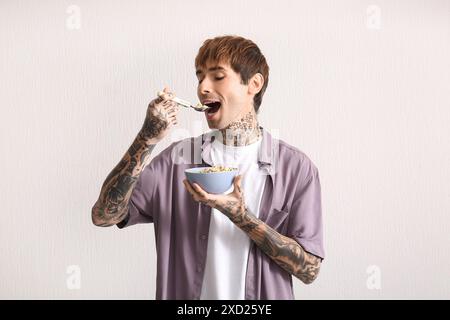 Man eating cereal rings on white background Stock Photo - Alamy