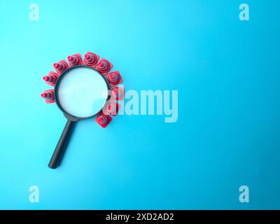 Mini plastic cones and magnifying glass on a blue background with copy ...