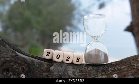 An hour glass with a dice cube and a text 2025 as a symbolic that the ...
