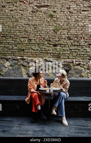 Two women engage in conversation inside professional office setting ...