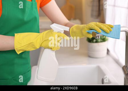 Professional janitor wearing uniform cleaning tap in kitchen Stock ...