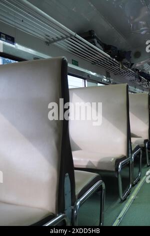 Economy class local Indonesian train seats with open windows in the ...