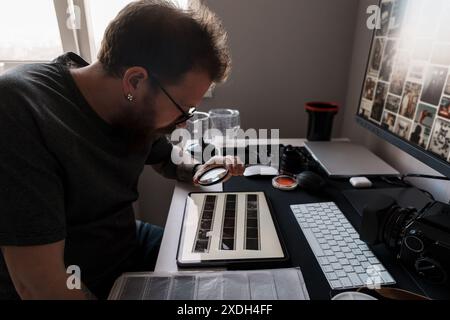 Photographer examining negatives with magnifying glass Stock Photo - Alamy