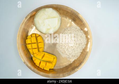 A copper plate and bowl of Dahi Chiura aka Yoghurt and Rice Flakes for ...