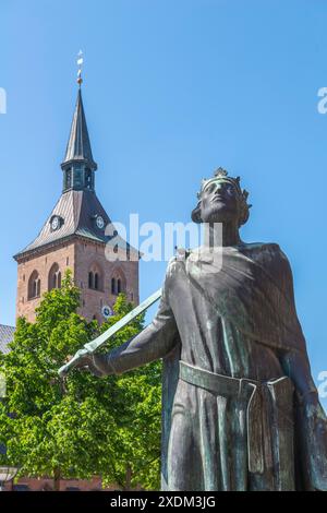 Odense, King Knud statue, crown, sword, tower of the cathedral church ...