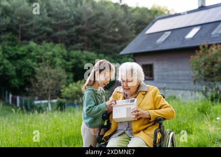 Granddaughter showing grandma solar panels on roof. Senior lady in ...