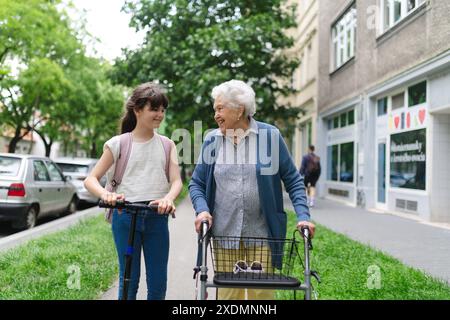 Grandma with walker picking up young girl from school at afternoon ...