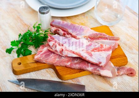 Fresh meaty pork ribs with condiments ready for cooking on wooden ...