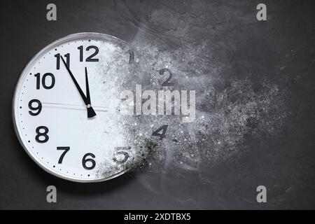 Flow of time. Analog clock dissolving on black background, space for ...