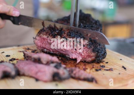 Man slices a piece of picanha into strips Stock Photo - Alamy