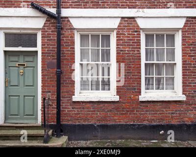 Brick home front view of English Tudor style with blooming gardens and ...