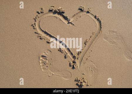 Heart shape and footprint on wet sand Stock Photo - Alamy