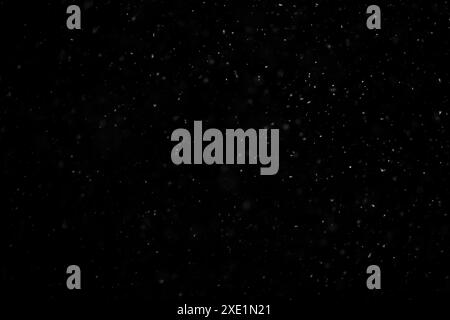 Falling white snow at night in the dark in a beam of light. Long ...