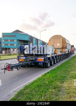 The truck with a very long multi-axle multi-tire semi-trailer carries a ...