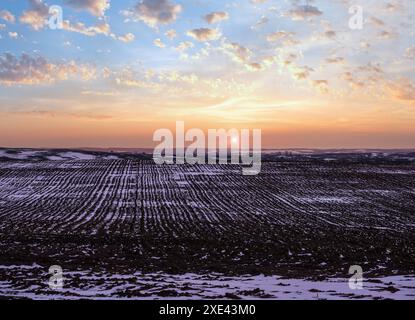 Black earth, arable land covered with the last snow, early spring. Calm ...
