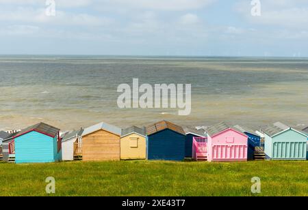 Colorful holiday beach huts homes facing the calm blue sea Stock Photo ...