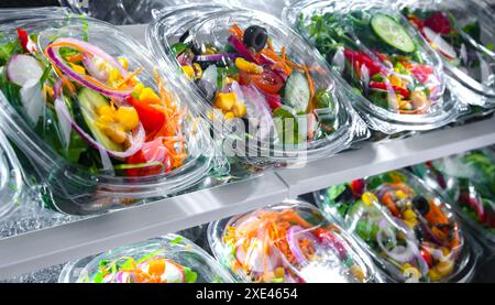 Plastic boxes with pre-packaged vegetable salads, put up for sale in a ...