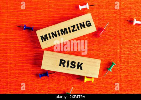 MINIMIZING RISK word written on wooden blocks laid out by hand on a ...