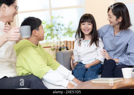 Family of four facing each other on a sofa Stock Photo - Alamy