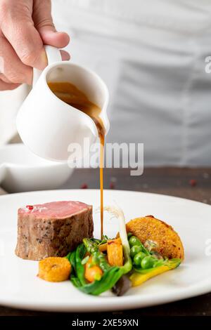 Filet mignon served with vegetables and sauces at a fine dining ...