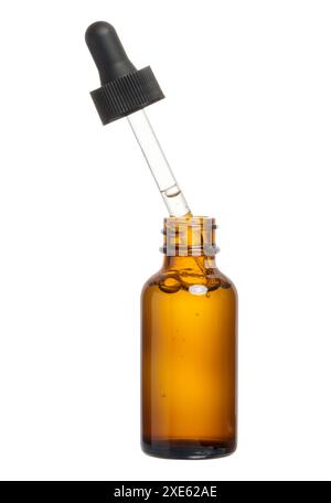 Glass brown bottle with dropper on a wooden plate and on a yellow ...