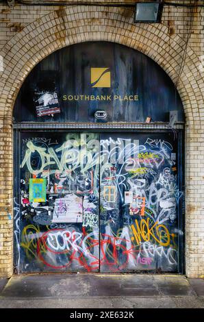 Graffiti on door on old railways arches close ot Waterloo Station ...