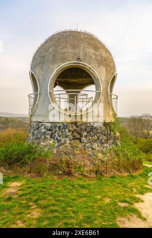 A unique modern concrete lookout tower with large circular windows ...