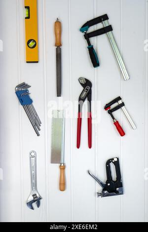 Organized hand tools hanging on workshop wall, ready for carpentry and ...