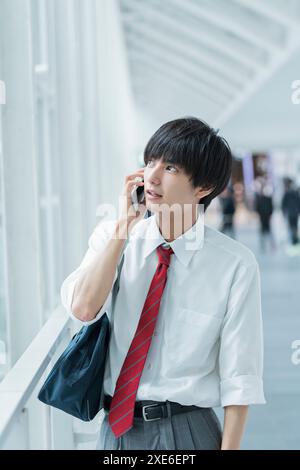 High school boy making a phone call on his way to school Stock Photo ...