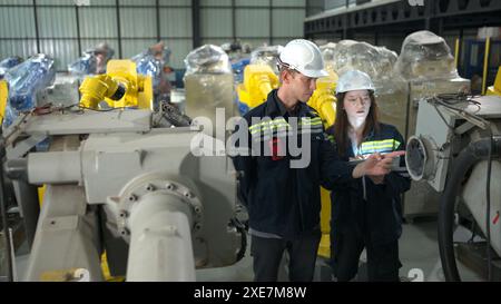 Both of engineers working together in a robotic arm factory, Robotic ...