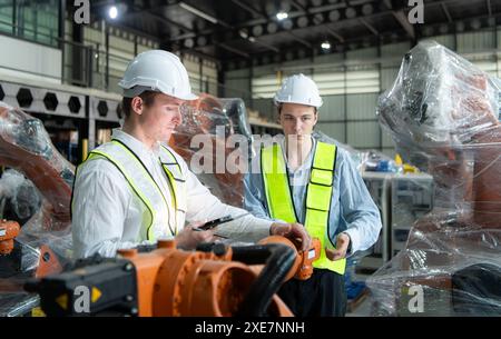 Both of engineers working together in a robotic arm factory, Robotic ...